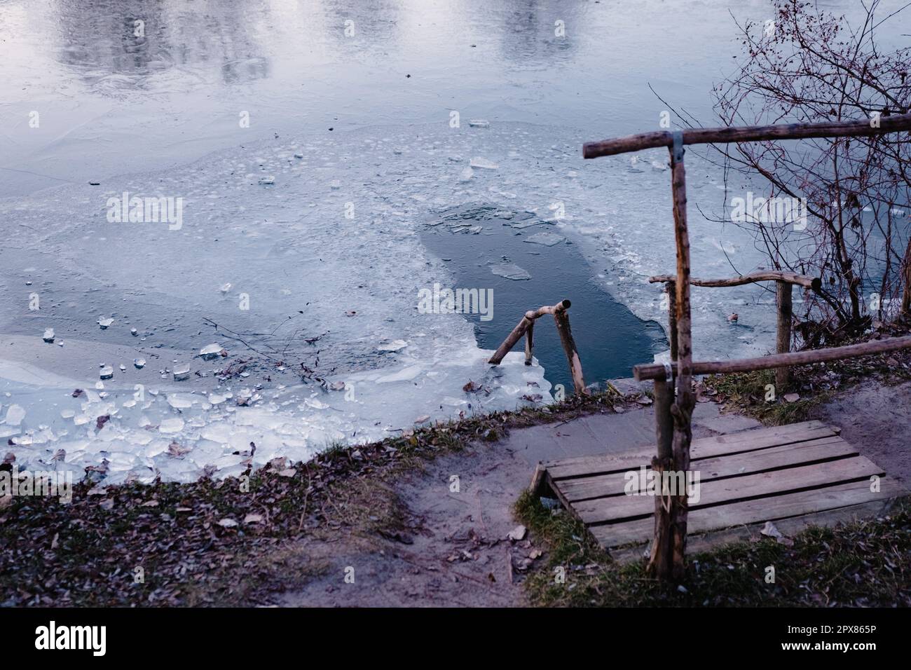 Ice swimming place in the river with wooden steps and rails. Cold snowy ...