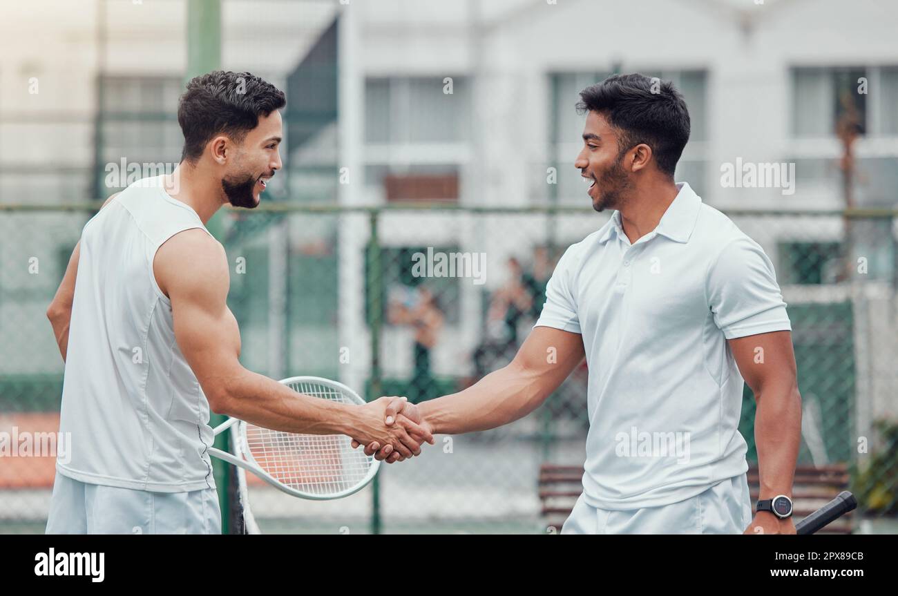 Two ethnic tennis players shaking hands before playing court game ...