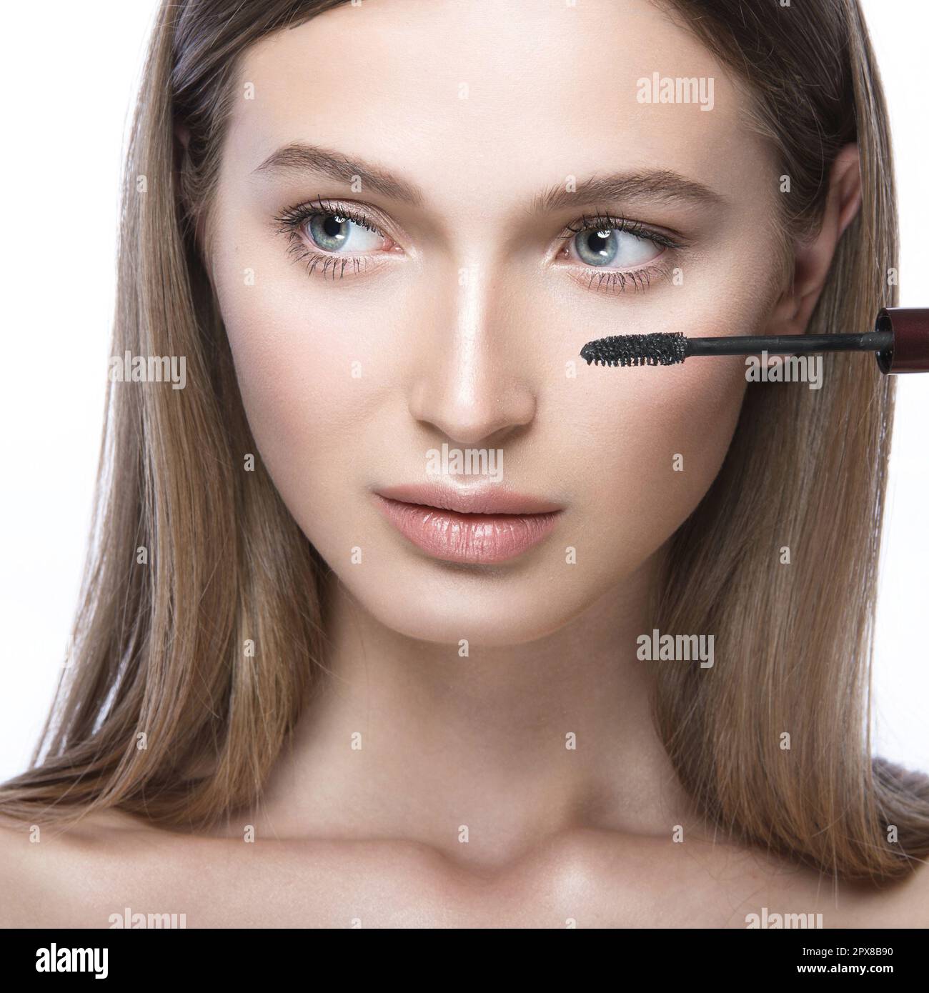 Beautiful young girl with a light natural make-up and beauty tools in ...