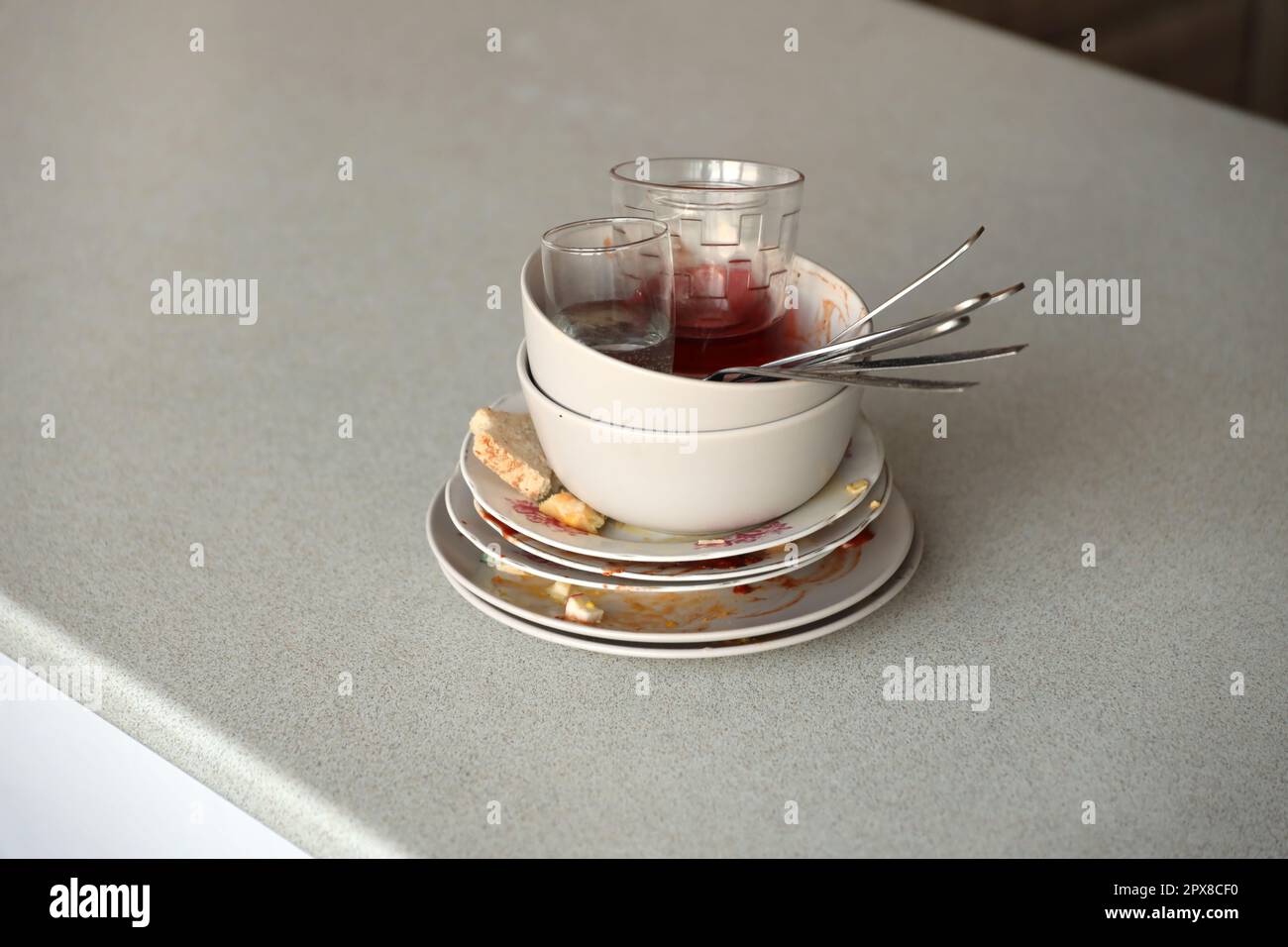 Stack of dirty dishes with food leftovers on the table after meal ...