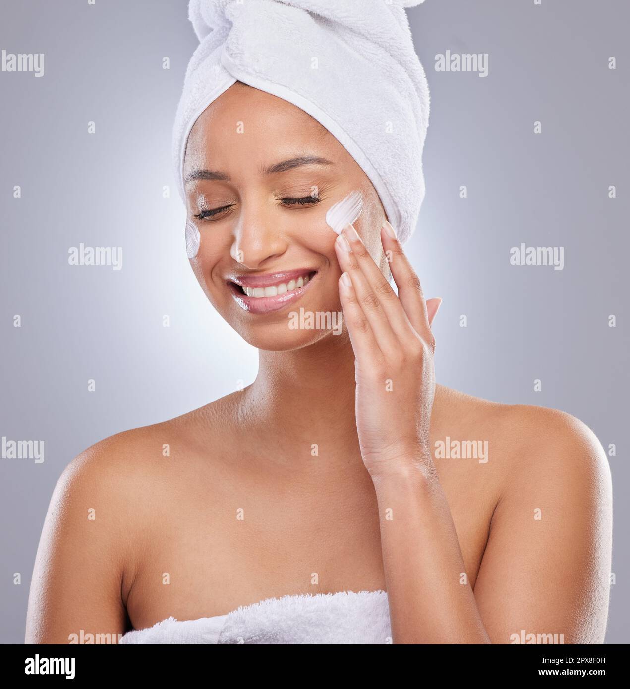 Keeping my skin hydrated. an attractive young woman applying ...