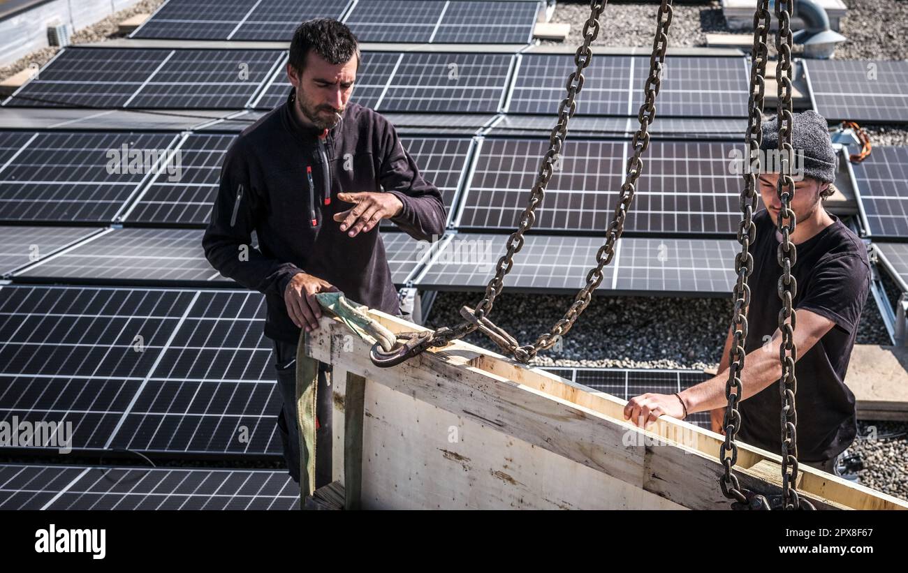 Male team engineers installing stand-alone solar photovoltaic panel ...
