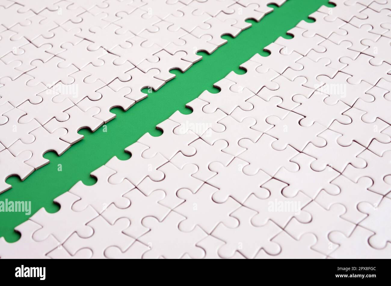 The green path is laid on the platform of a white folded jigsaw puzzle ...