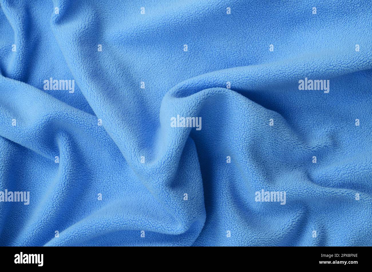 The blanket of furry blue fleece fabric. A background of light blue ...