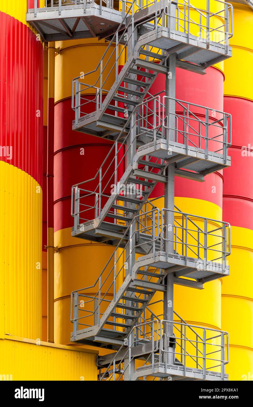 An external metal staircase on the silos in a petrochemical factory ...