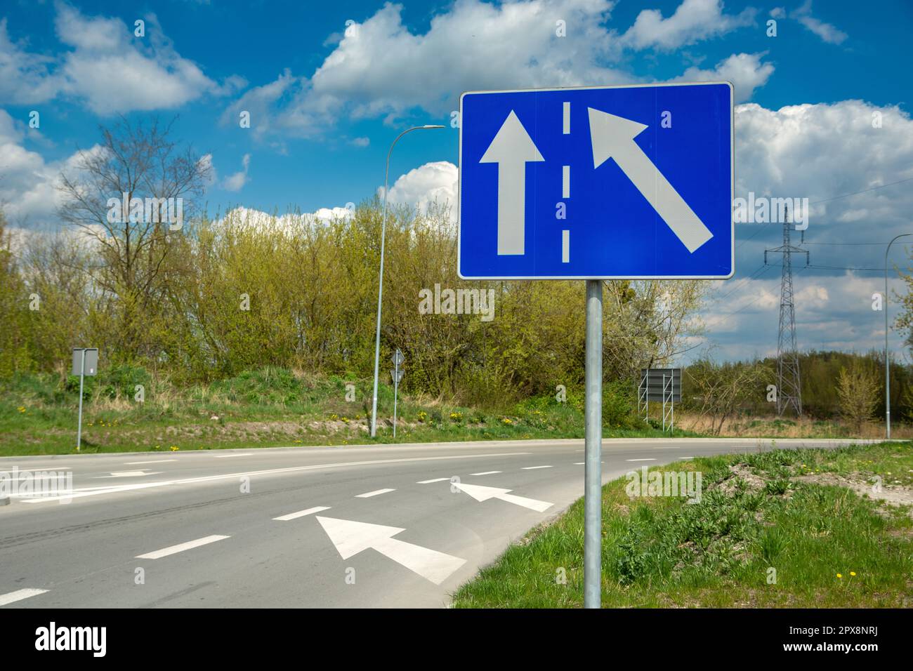 Blue rectangle road sign and white arrows, spring day Stock Photo - Alamy