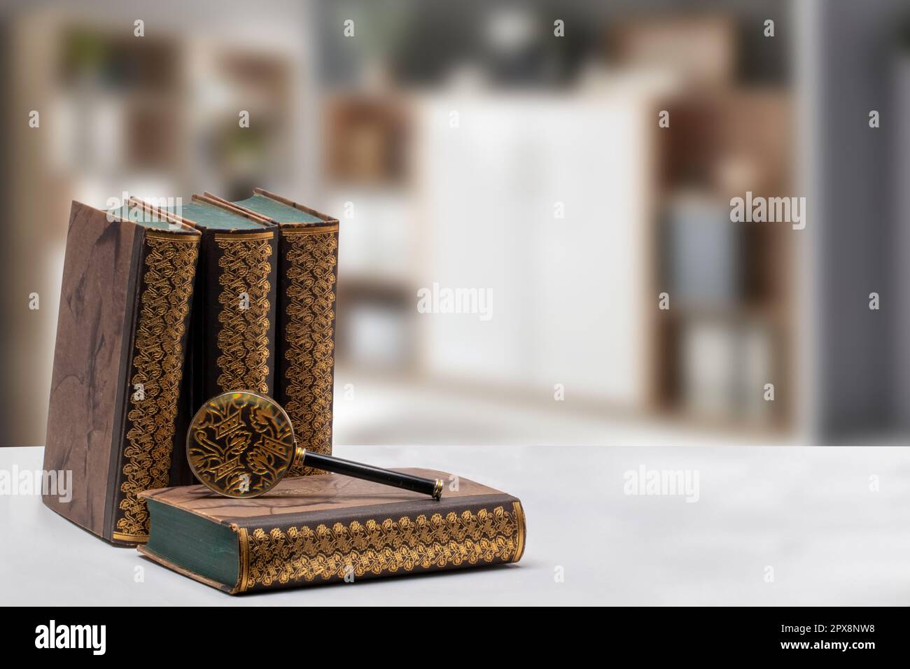 Ancient books with a magnifying glass on a bright table isolated over ...