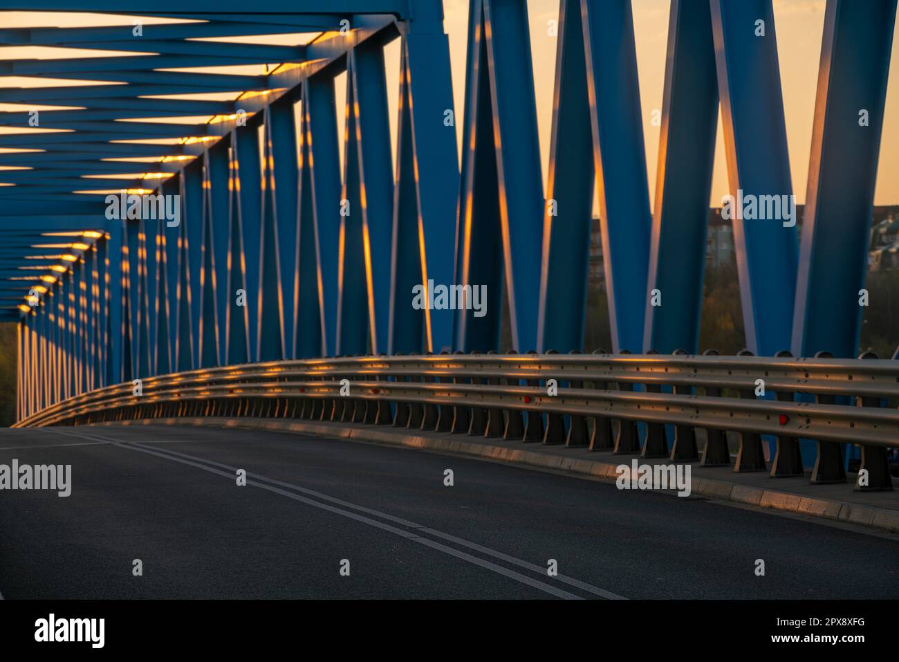 Asphalt road running over a truss bridge at sunset Stock Photo - Alamy