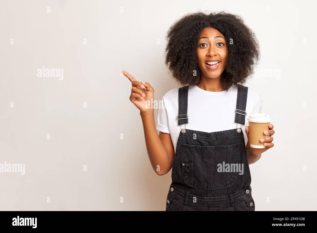 Positive woman pointing finger a side, isolated next to white ...