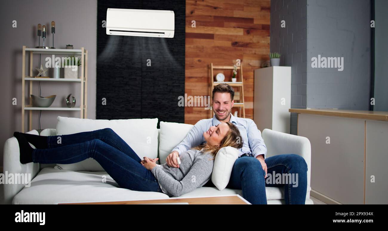 Happy Family Couple Using Air Conditioner. Apartment AC Stock Photo - Alamy