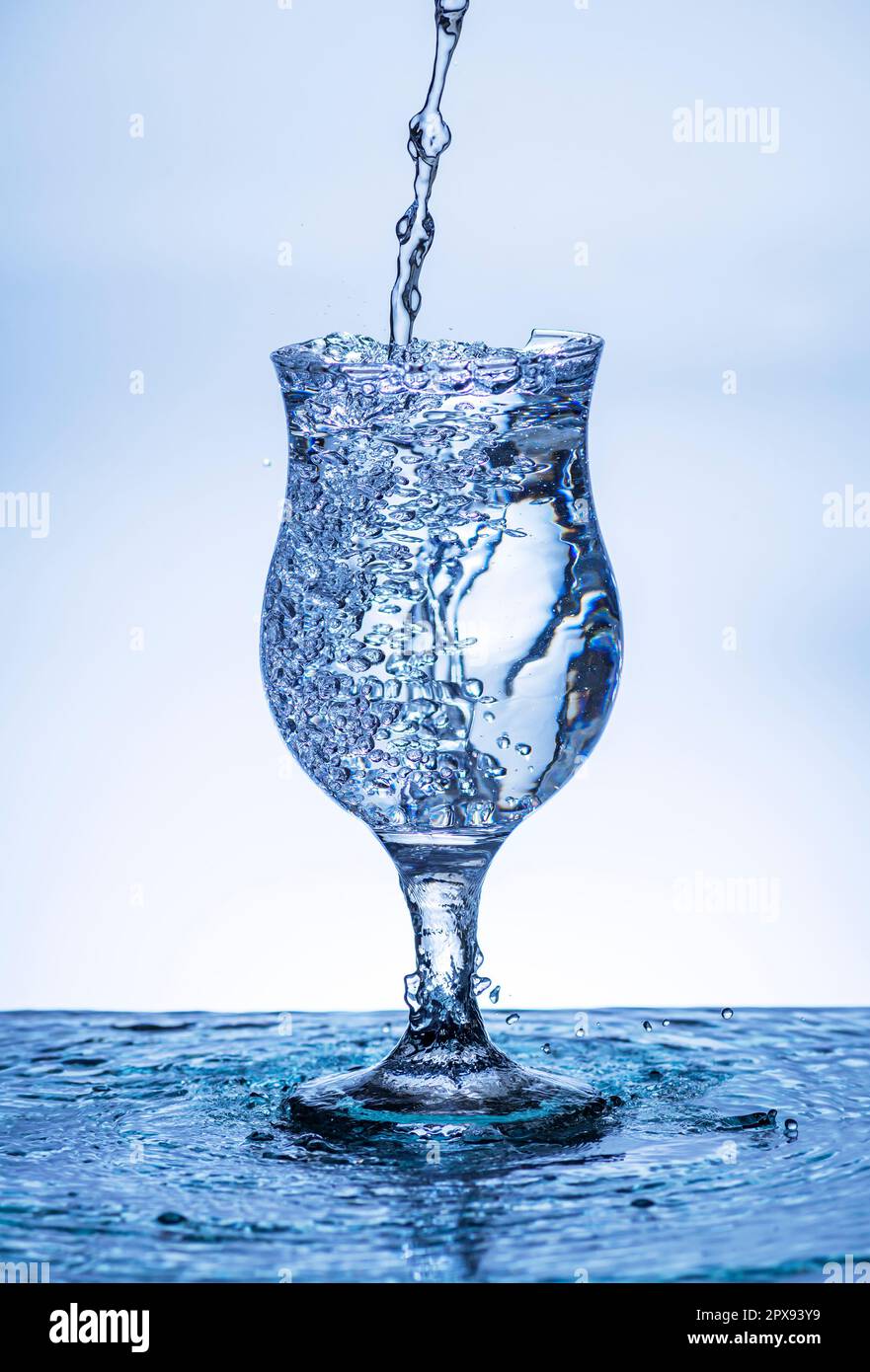 The image of pouring drinking water, into a broken glass, that makes ...