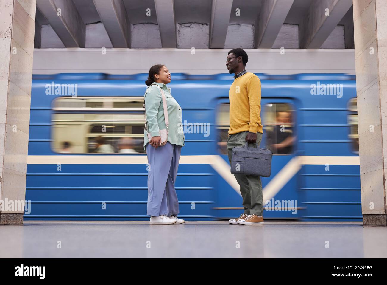 African American couple meeting in subway and talking while waiting for ...