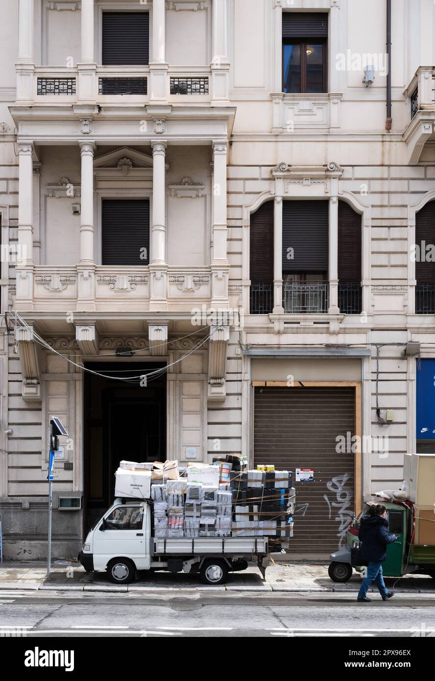 A motor scooter loaded with many packages over the roof stands in front ...
