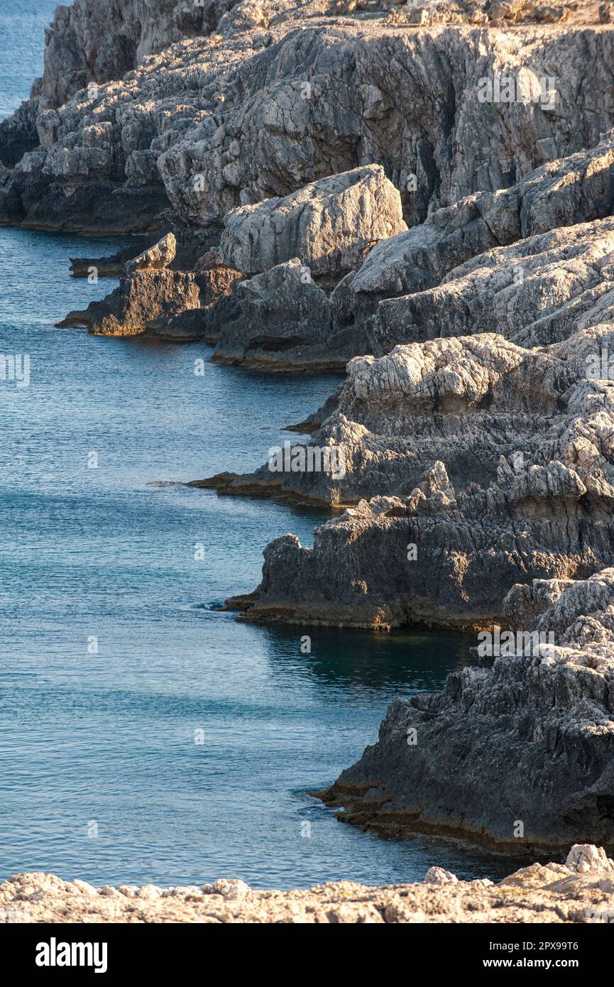 Rocky coast with rugged cliffs on the coast of the Greek island of ...