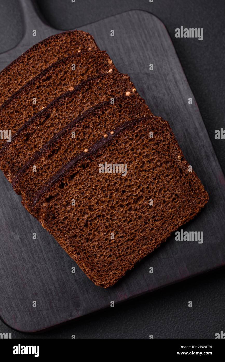 Delicious fresh brown bread with grains and seeds sliced on a wooden ...