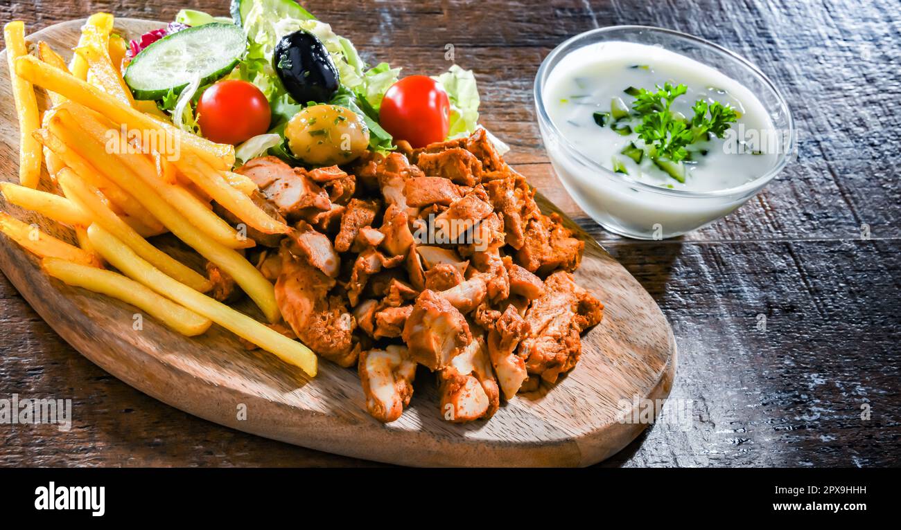 Kebab served with french fries, vegetable salad and tzatziki Stock ...