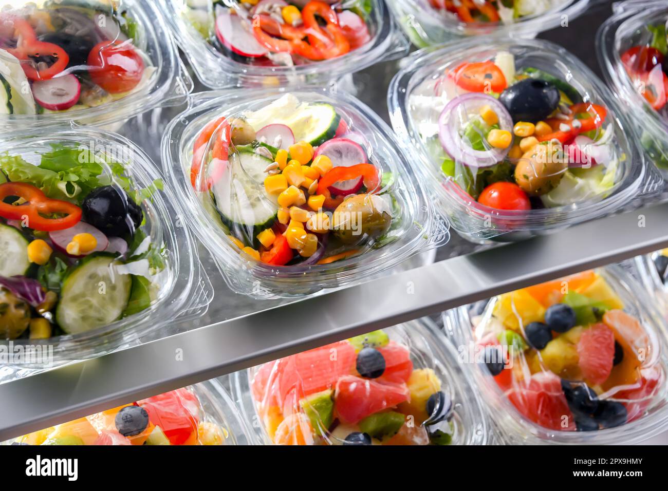 Plastic boxes with pre-packaged vegetable salads, put up for sale in a ...