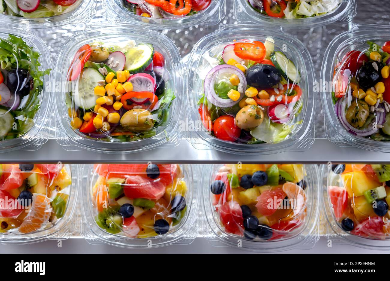 Plastic boxes with pre-packaged vegetable salads, put up for sale in a ...