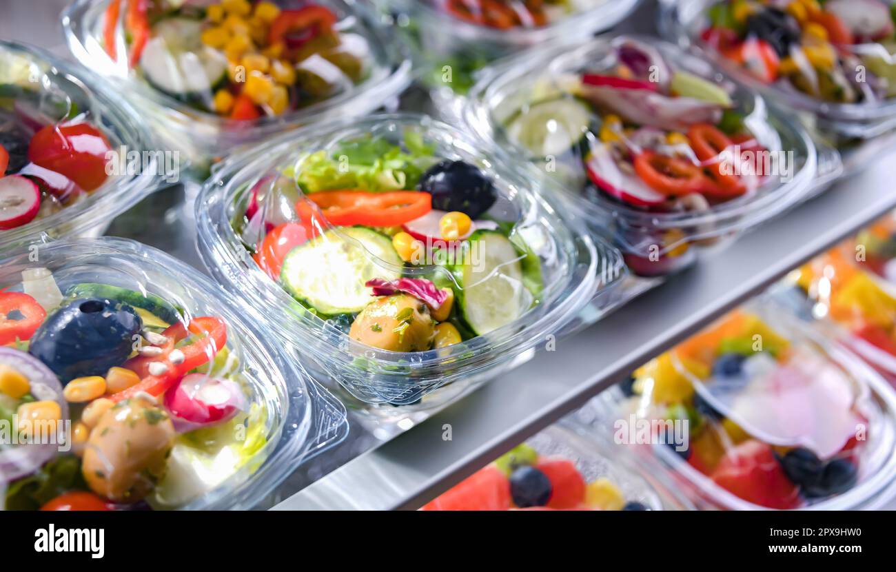 Plastic boxes with pre-packaged vegetable salads, put up for sale in a ...