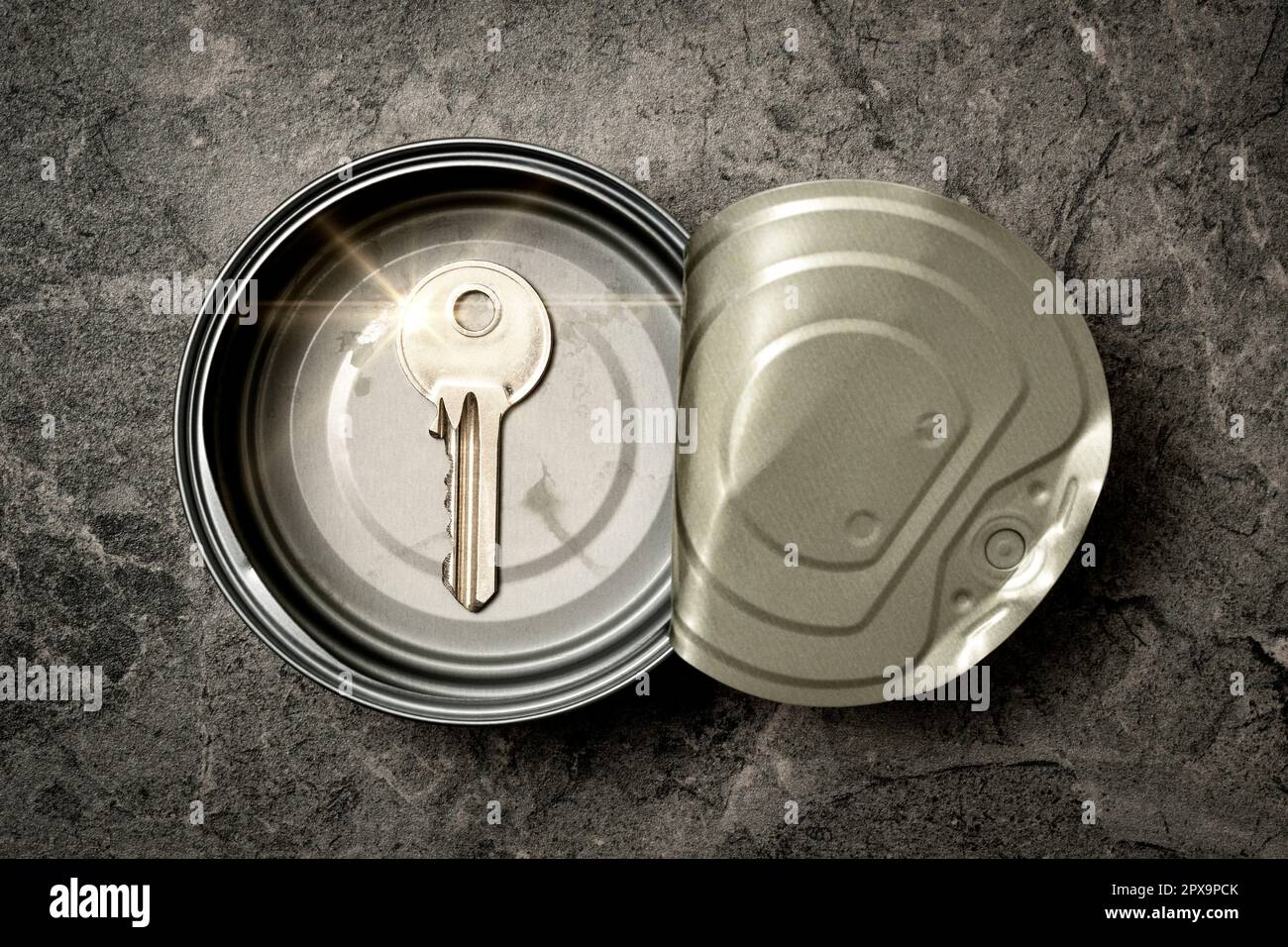 Opened tin can with a shiny key inside. Conceptual image Stock Photo ...