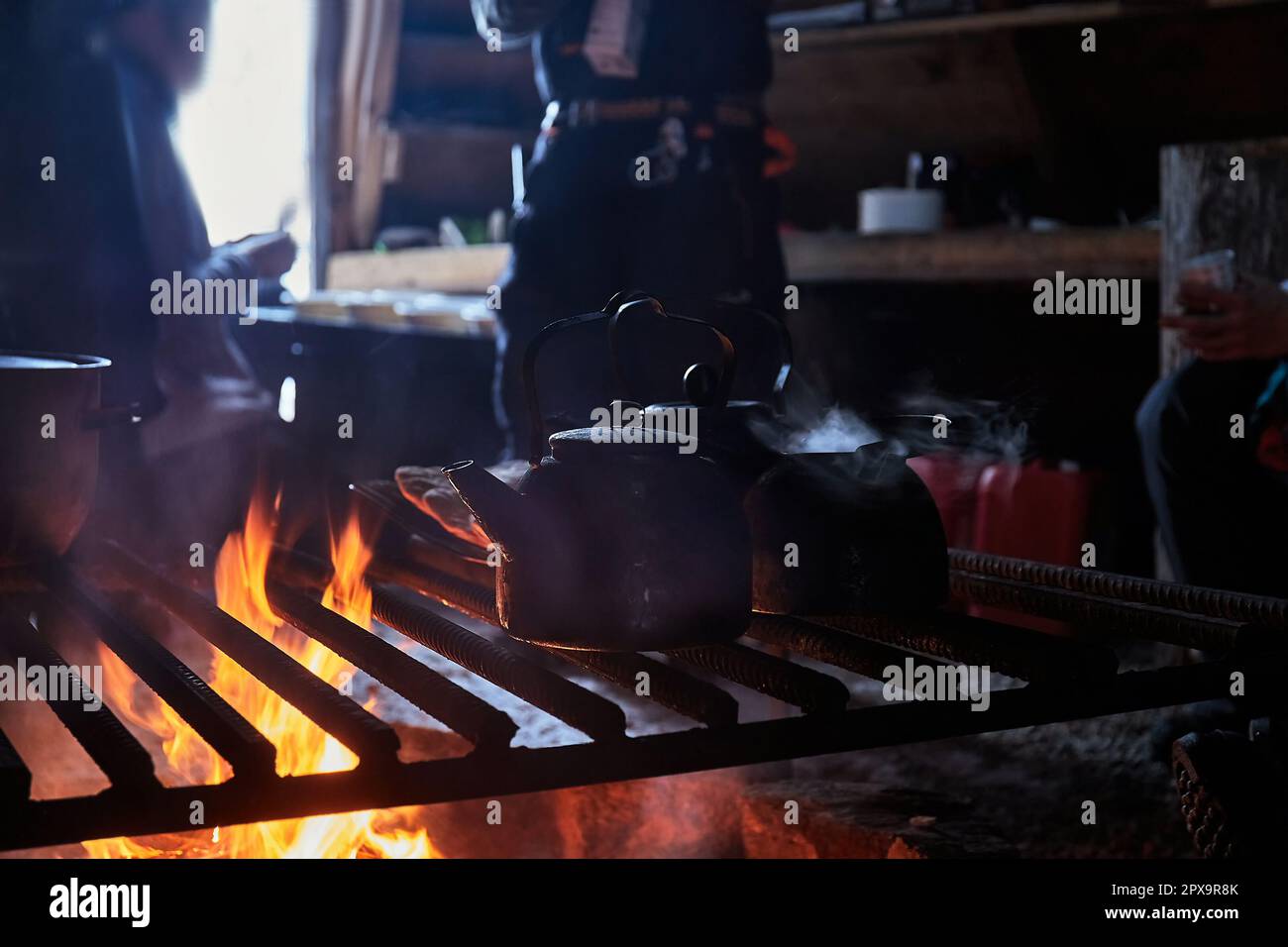 Fireplace, wood fire cooking soup and making tea in a ooden hut in the ...