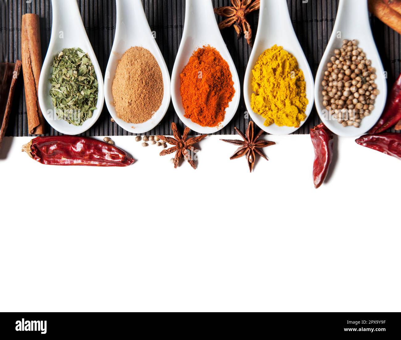 Top view on mixed dry colorful spices in spoons isolated on white ...
