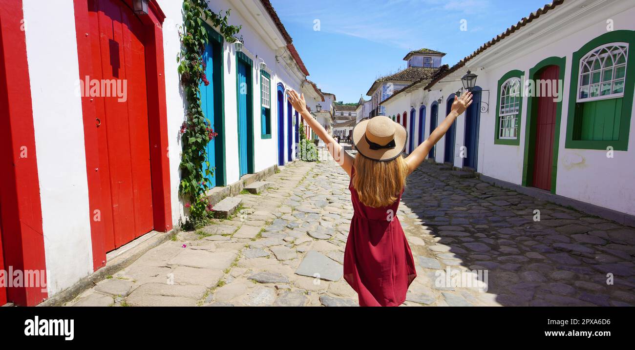 Joyful girl in Brazil. Beautiful young woman with raised arms walking ...