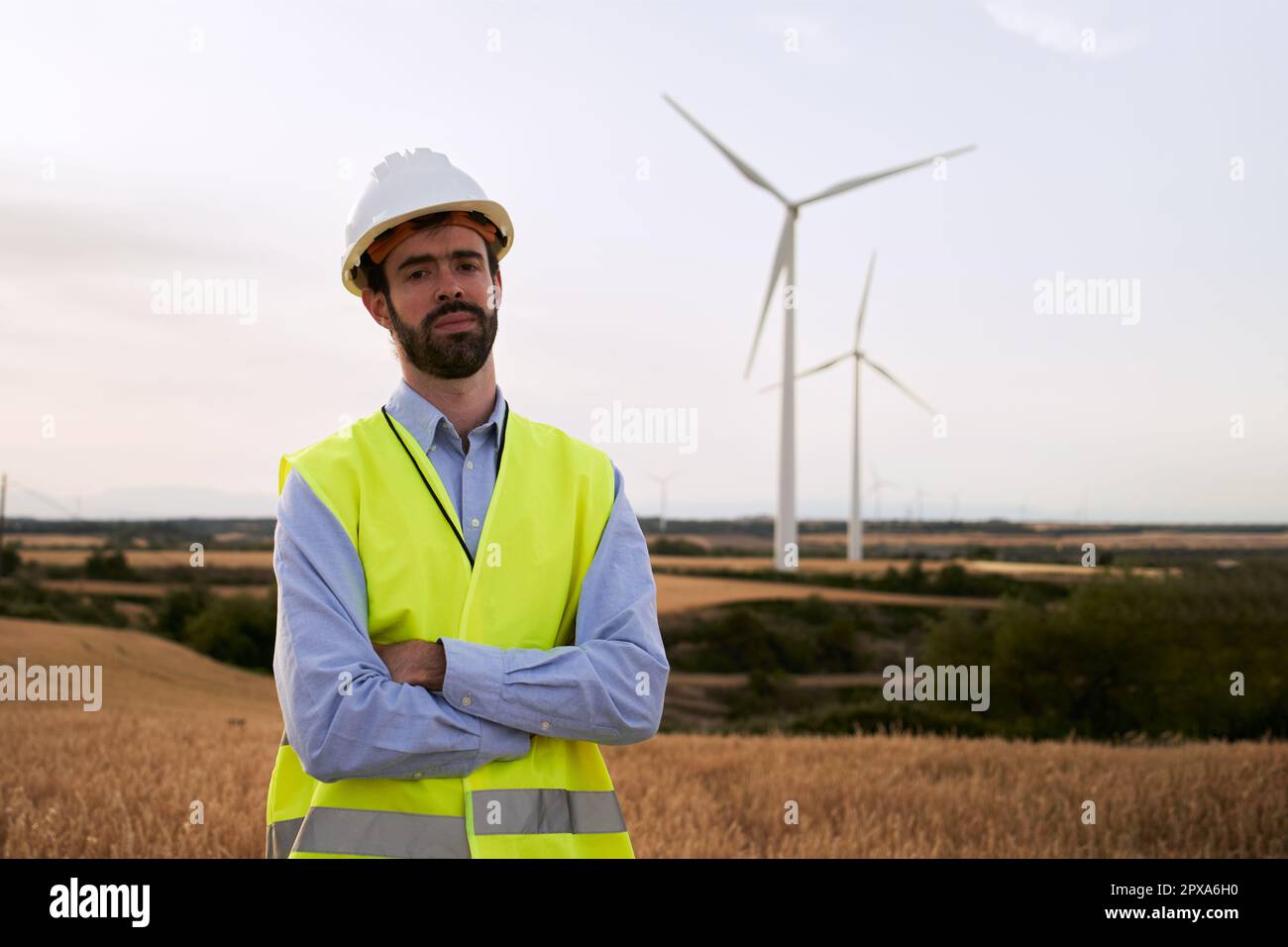 Technical engineer poses confidently with arms crossed looking at ...