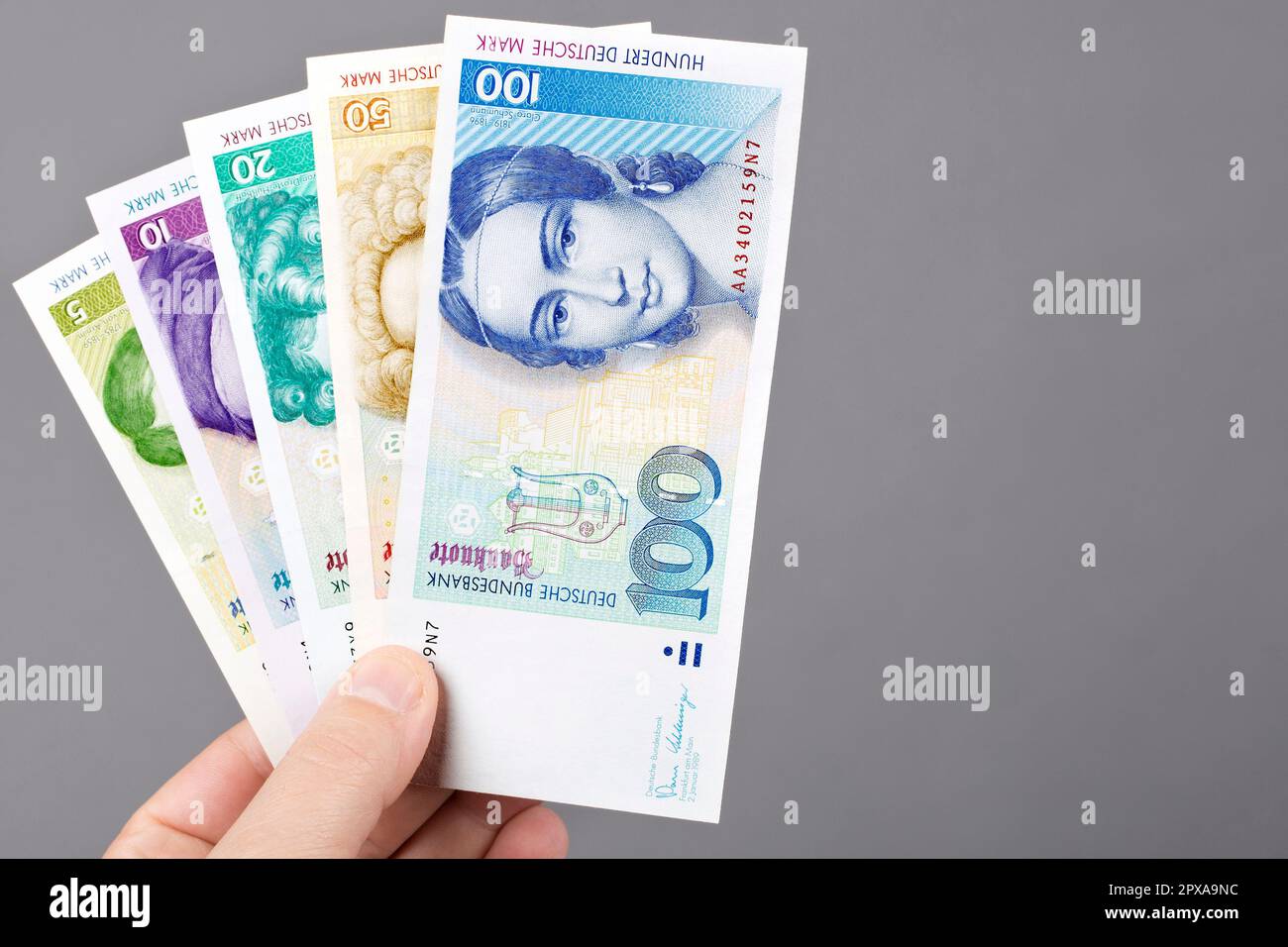 Deutsche money - Mark in the hand on a gray background Stock Photo - Alamy