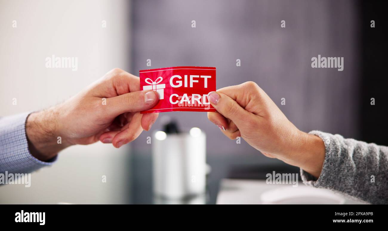 Hand Giving Gift Voucher Card. Holding Prepaid Coupon Stock Photo - Alamy