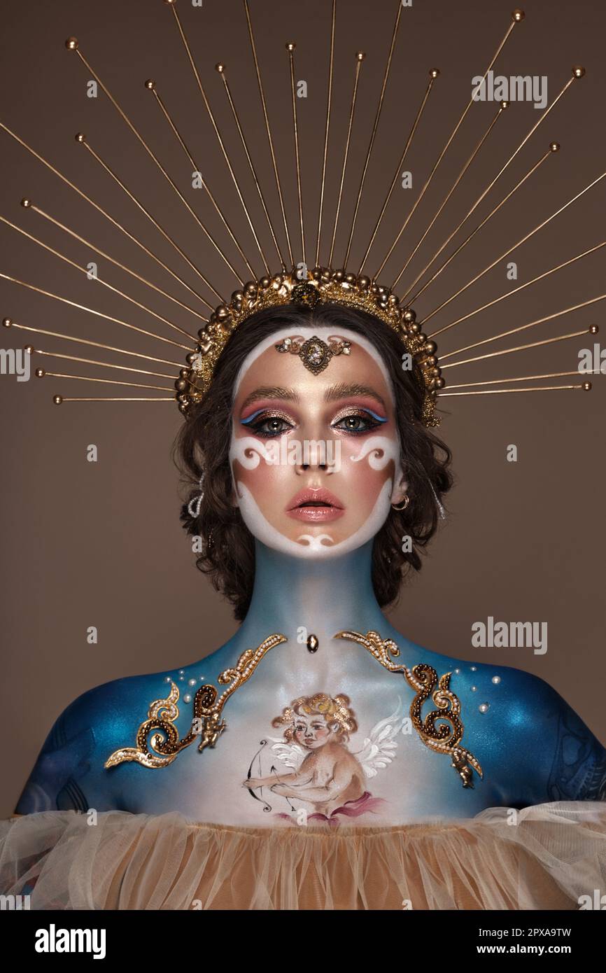 Portrait of a girl with gold and blue creative art make-up. Photo taken in the studio ...