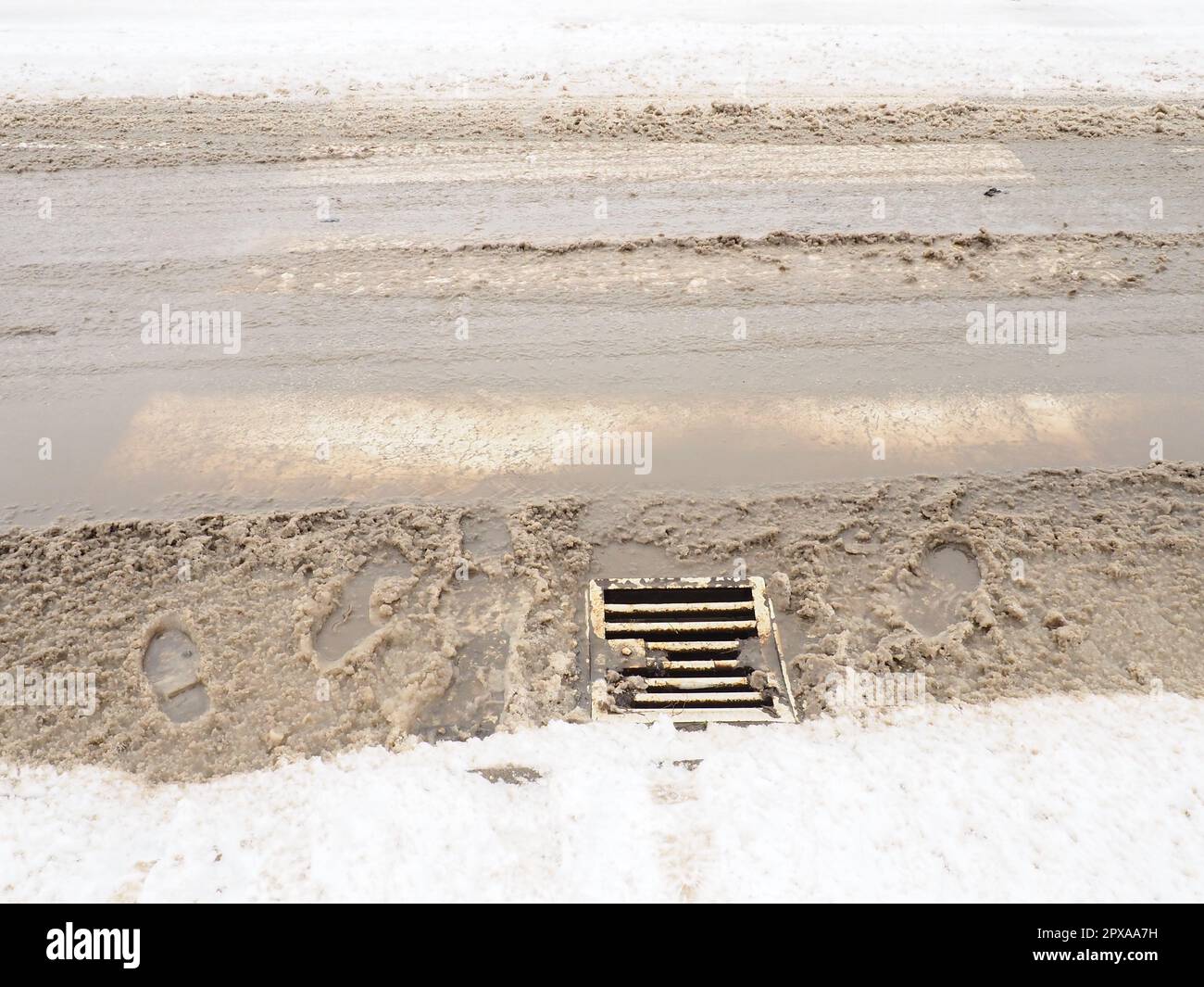 Snow, ice, slush and winter mud at a pedestrian crossing. The air ...