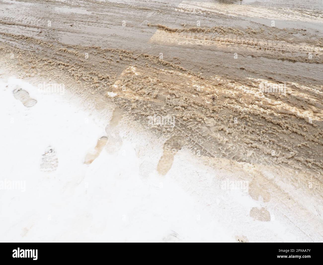 Snow, ice, slush and winter mud at a pedestrian crossing. The air ...