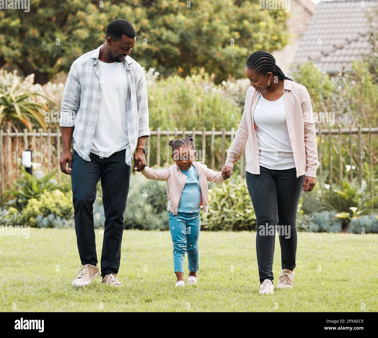 A lovely Sunday stroll. a young family strolling through their garden ...