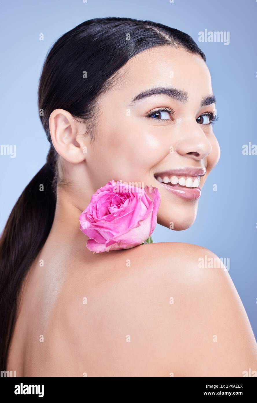 Studio portrait of a beautiful mixed race woman posing with a flower ...