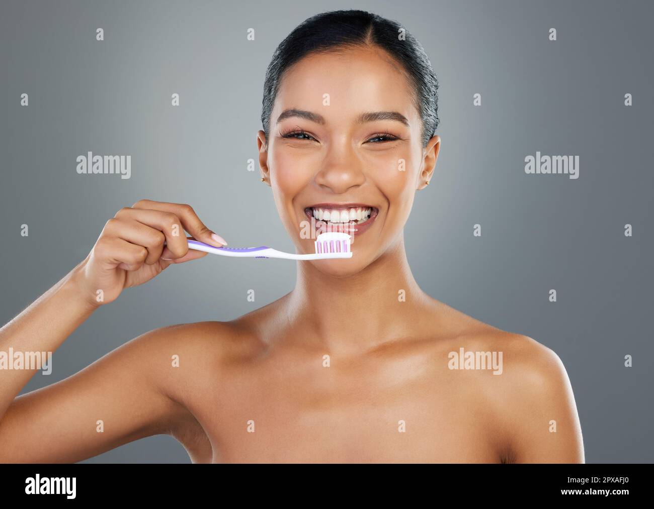 Oral hygiene is a big thing. a beautiful young woman brushing her teeth ...