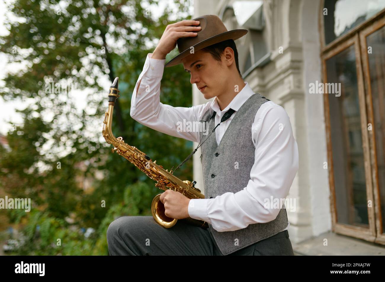 Portrait of young musician wearing heat and stylish outfit holding ...