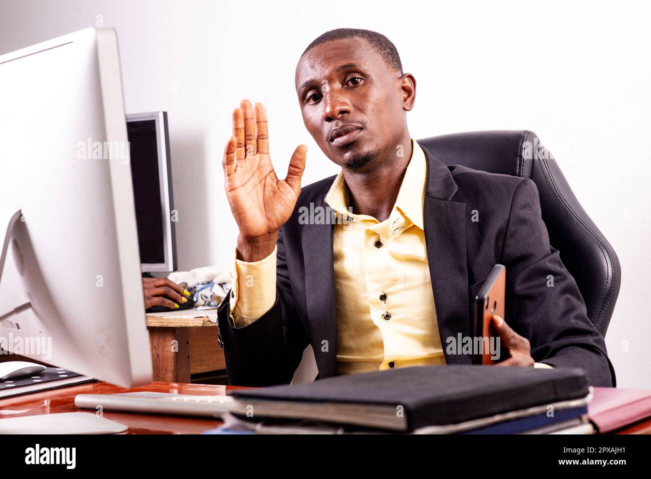 Portrait Of A Serious Young Businessman Sitting Down Gesturing His Hand