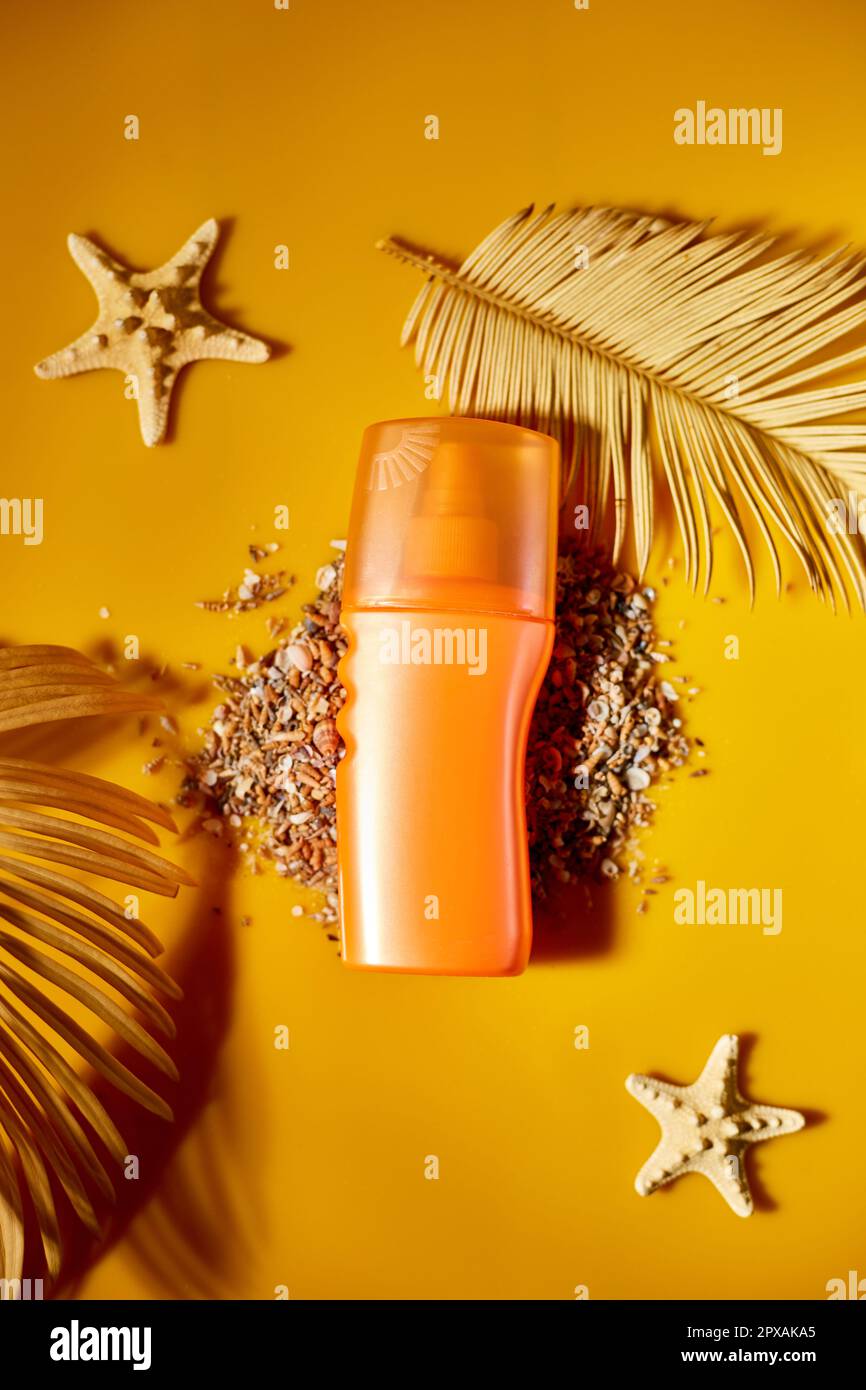 Top view, flat lay Sunscreen tube mockup with shells, sand yellow ...
