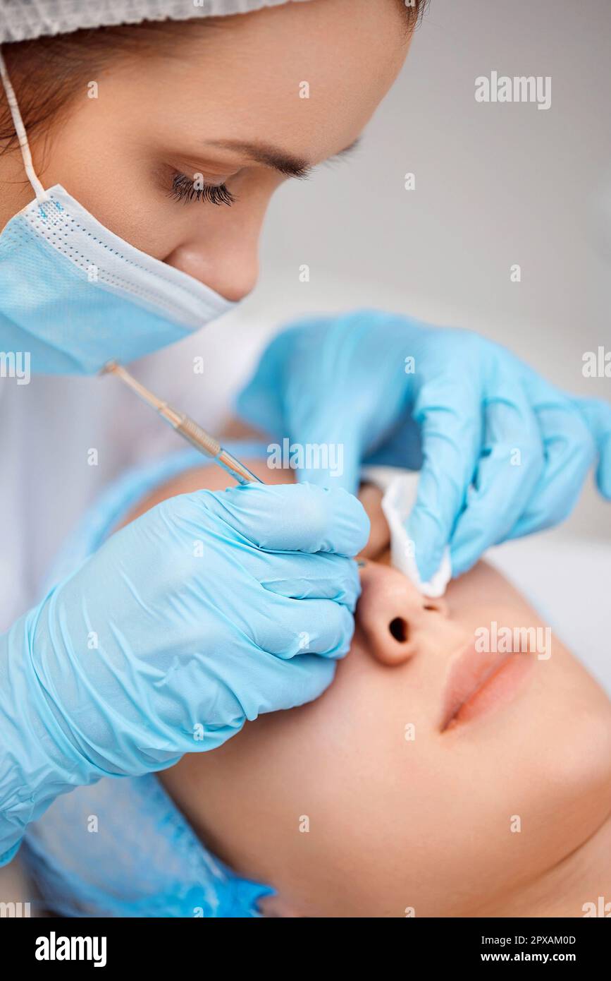 young woman during a mechanical face cleansing procedure at beauty ...