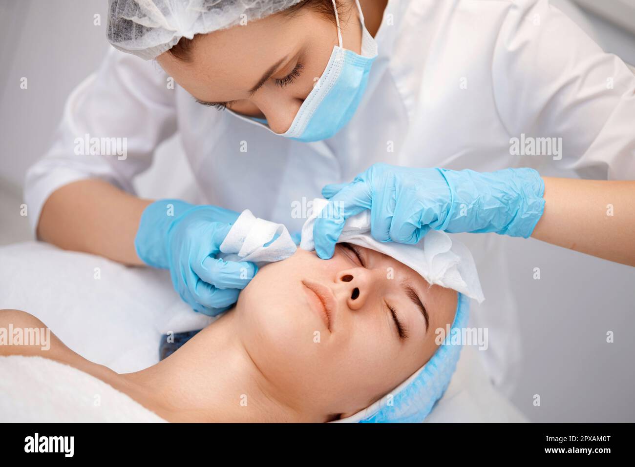 young woman during a mechanical face cleansing procedure at beauty ...