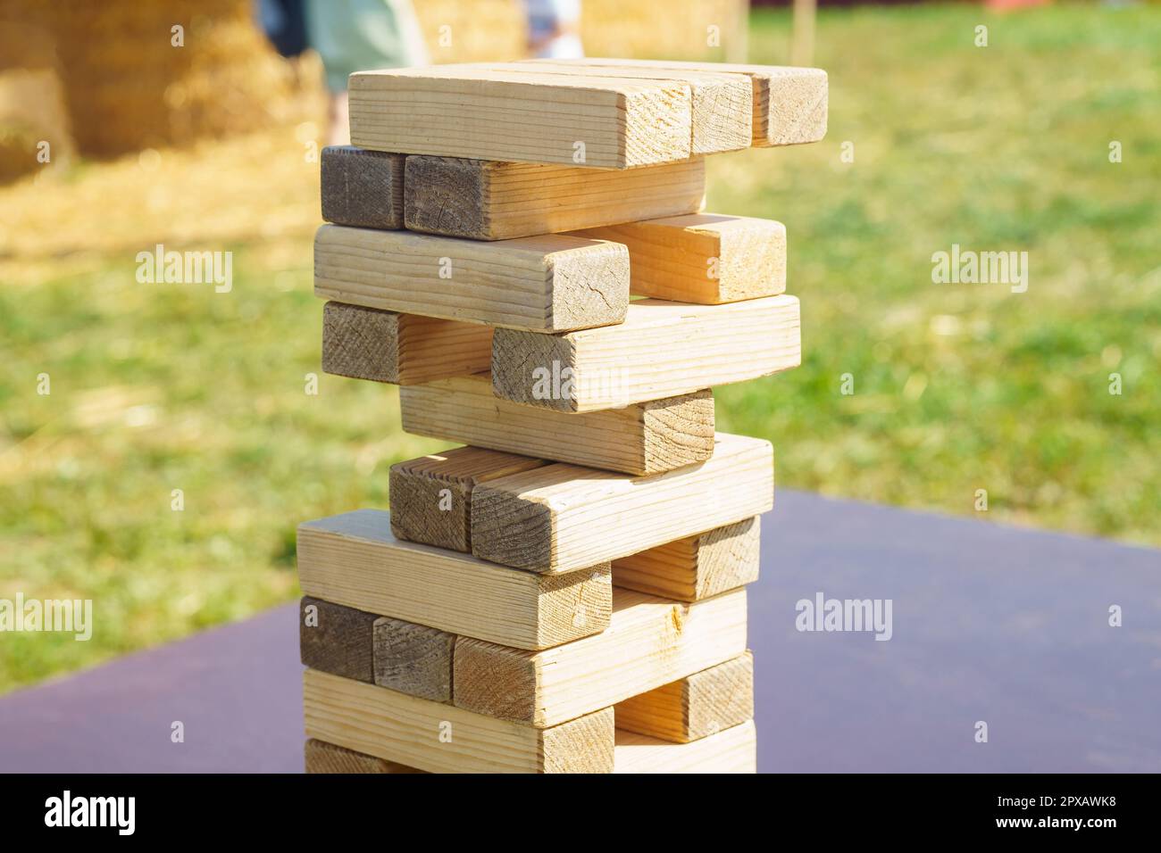 Side view of board game Jenga tower made of wooden blocks beams details ...
