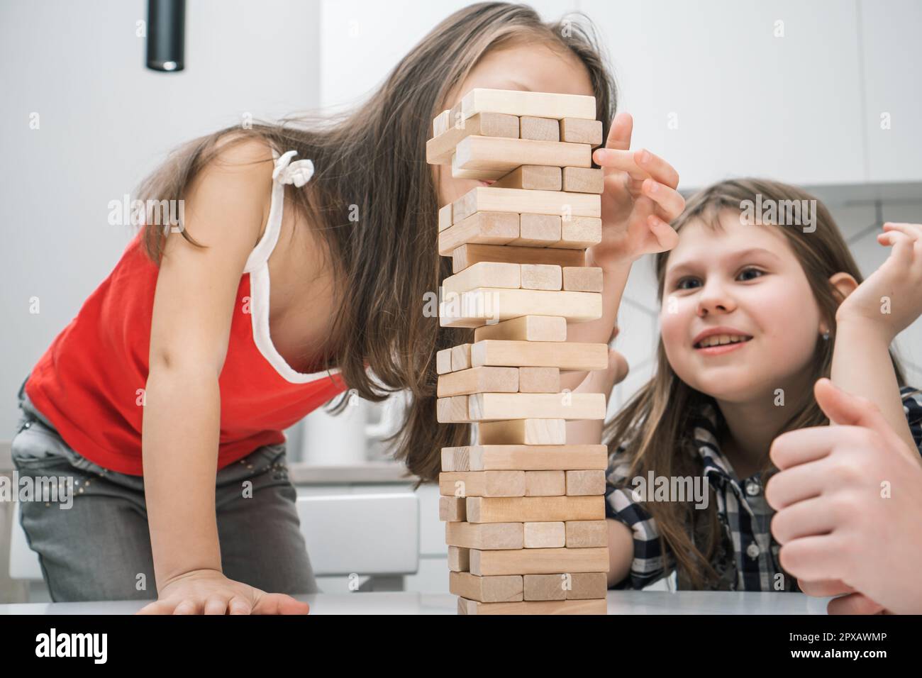 Group of enthusiastic children players playing board game Jenga on ...