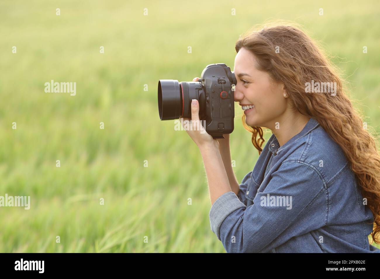Side view portrait of a woman taking photos in a field Stock Photo - Alamy