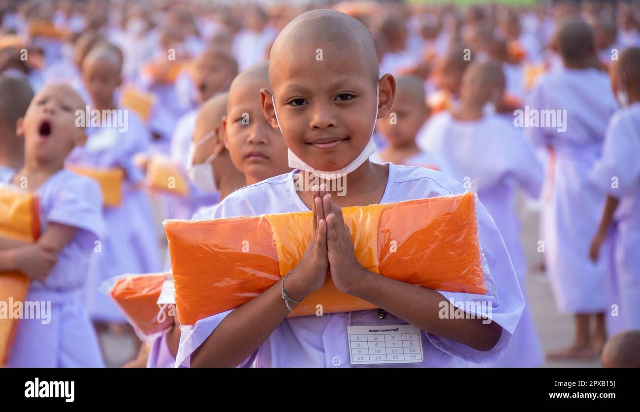 Devotees take part in the mass ordination ceremony at Wat Phra ...