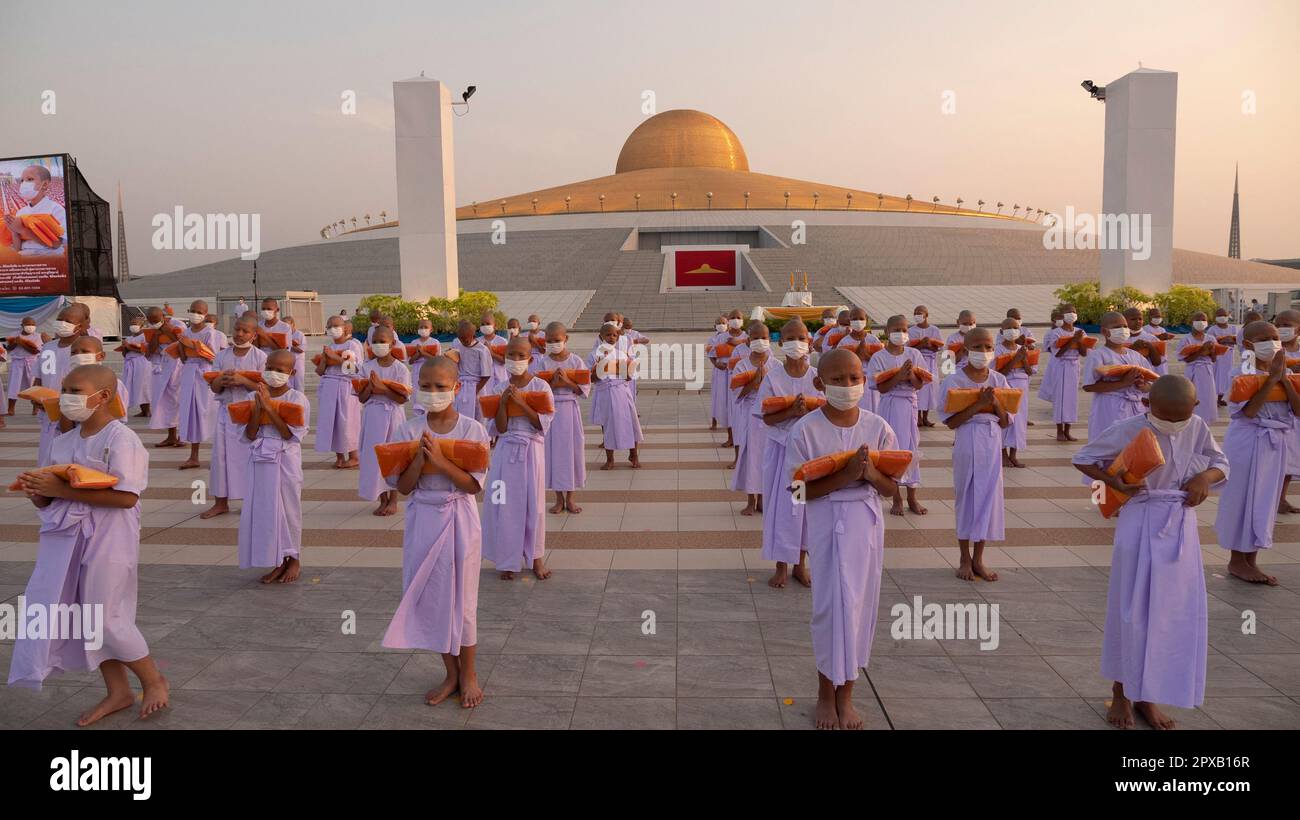 Devotees take part in the mass ordination ceremony at Wat Phra ...