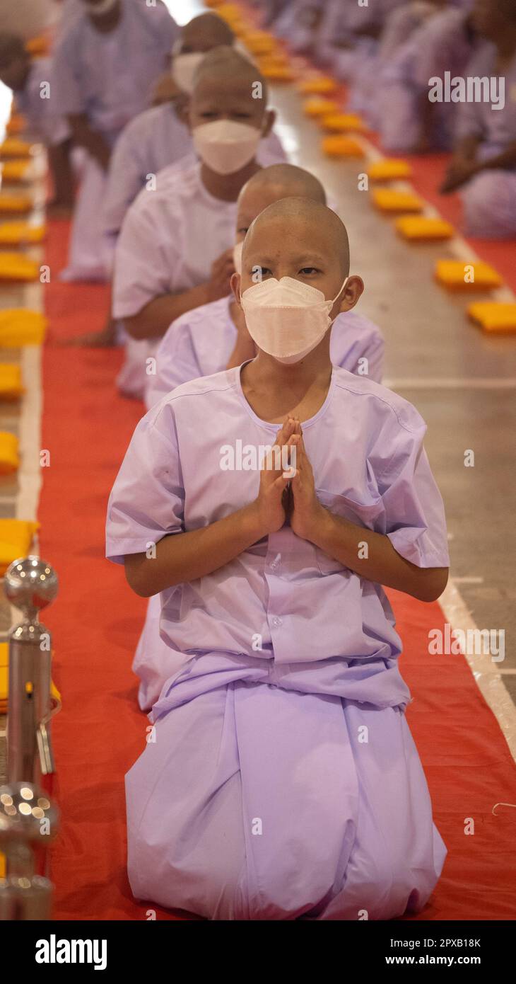Devotees take part in the mass ordination ceremony at Wat Phra ...