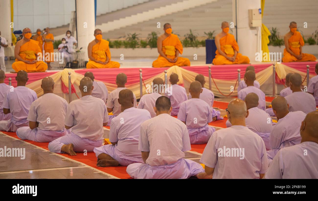 Devotees take part in the mass ordination ceremony at Wat Phra ...