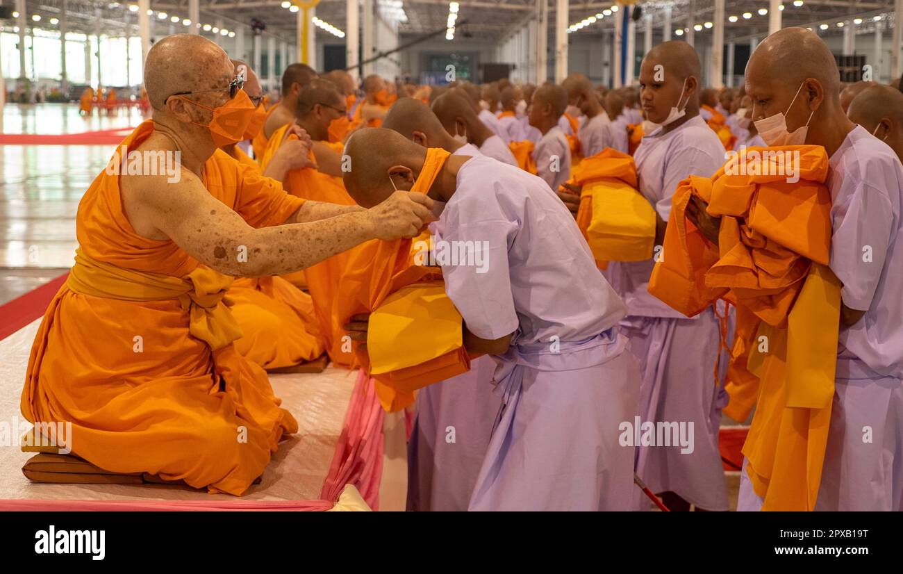 Devotees take part in the mass ordination ceremony at Wat Phra ...