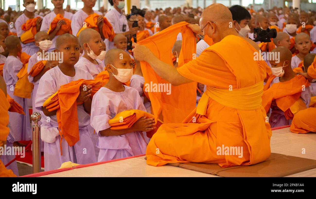 Devotees take part in the mass ordination ceremony at Wat Phra ...